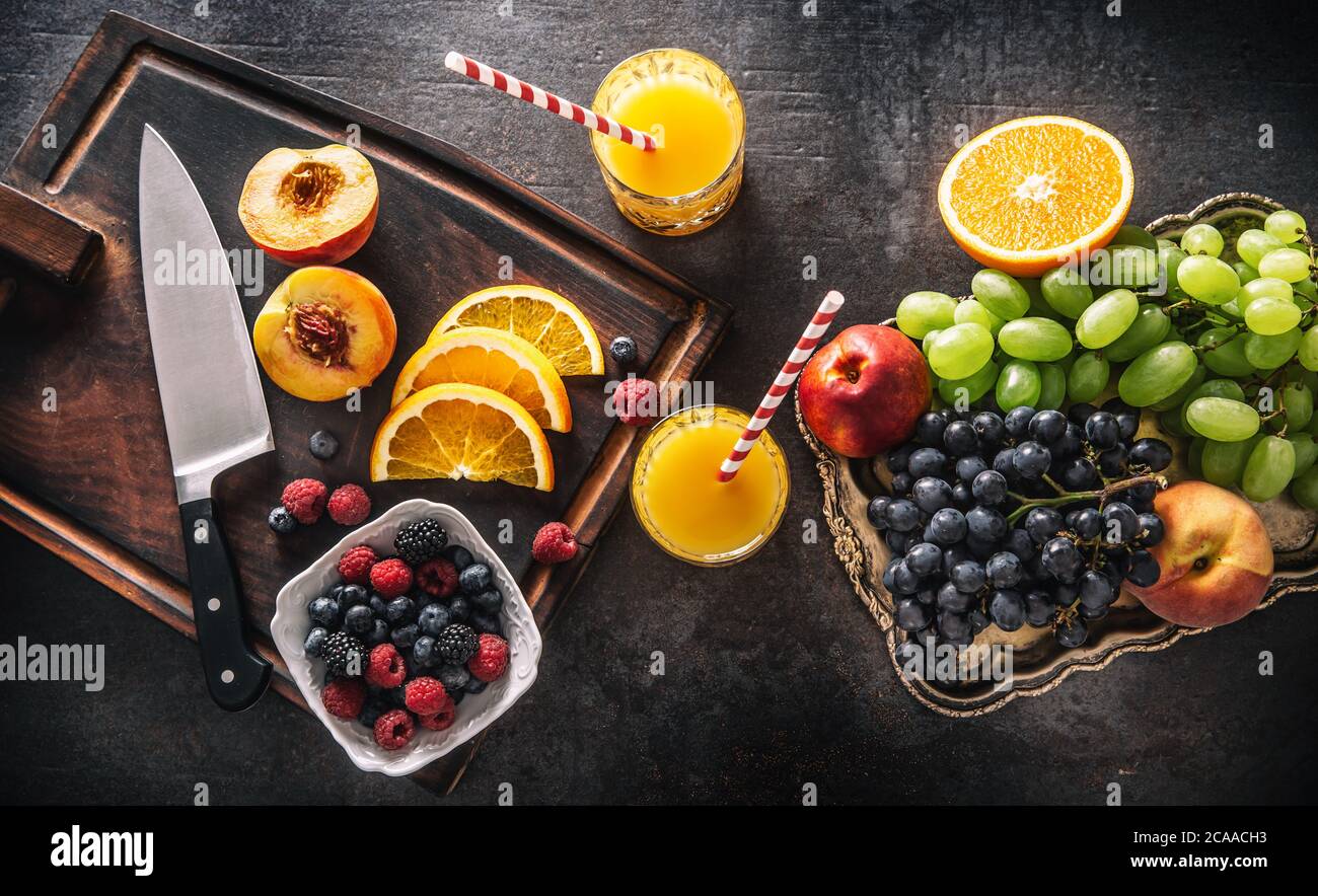 Top of view fresh fruits juice orange grapes peach berries on concrete ...