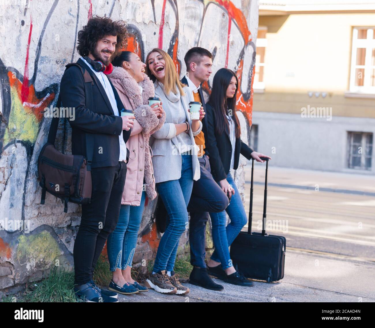 Three positive multiethnic colleagues talking hi-res stock photography ...