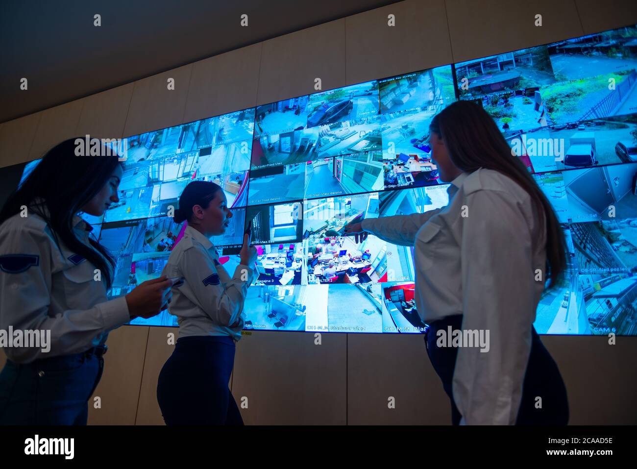 Security guards standing in front of a large CCTV monitor at the main ...
