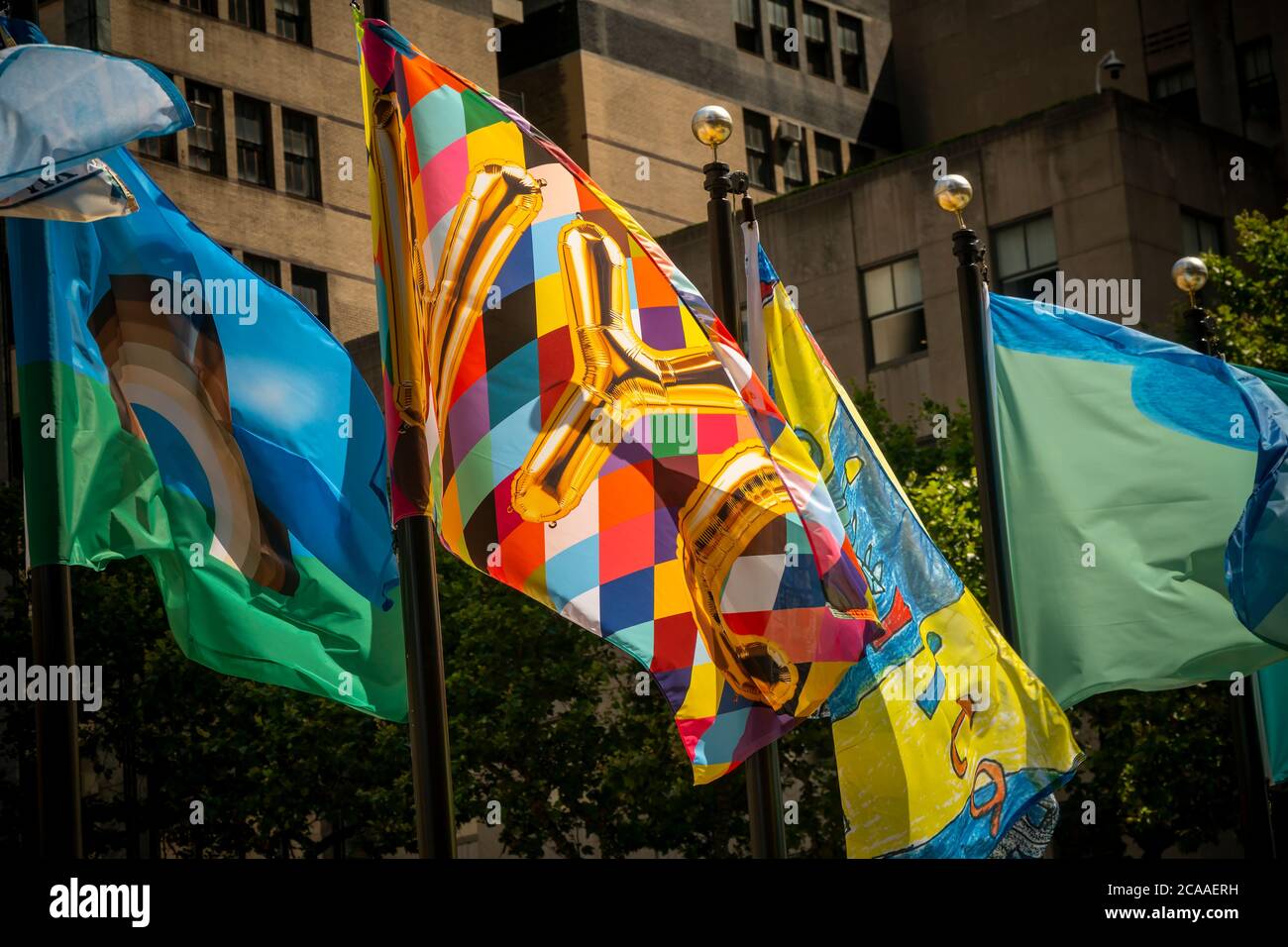 The flag designed by Jeff Koons, center, joins the 193 flags ...