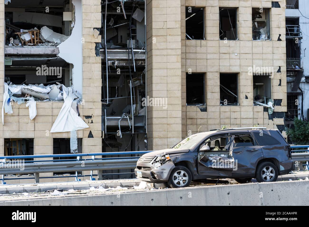 Damaged car in front of offices with shattered windows after a massive ...