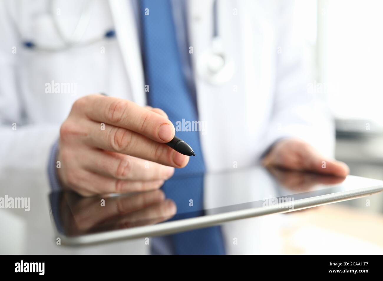 Doctor making notes on graphics tablet close up Stock Photo - Alamy