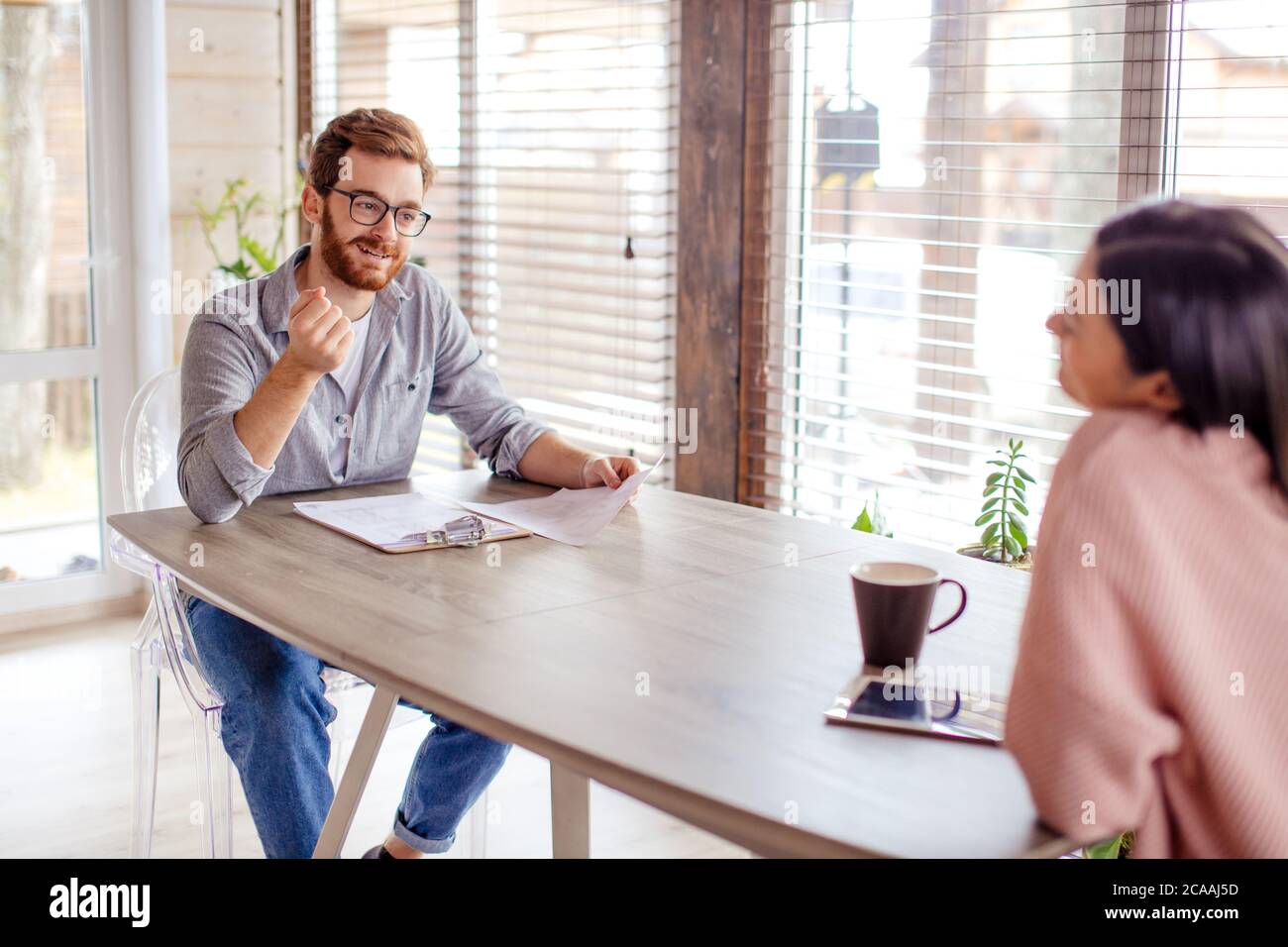 Business people sharing their ideas sitting in well lit airy stuff room ...