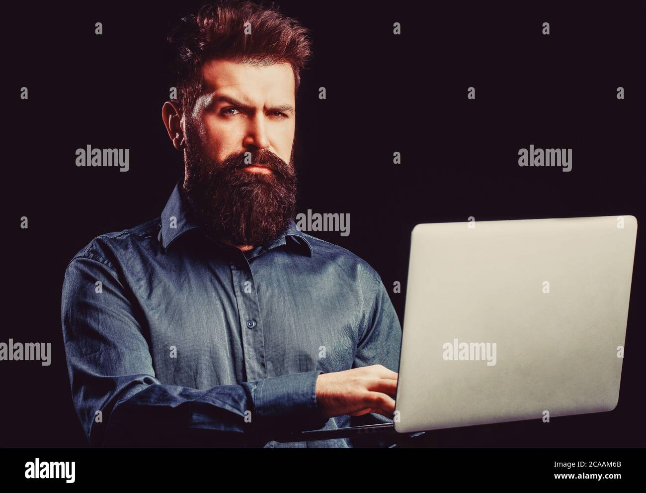 Bearded male businessman holding a computer in his hands isolated on ...