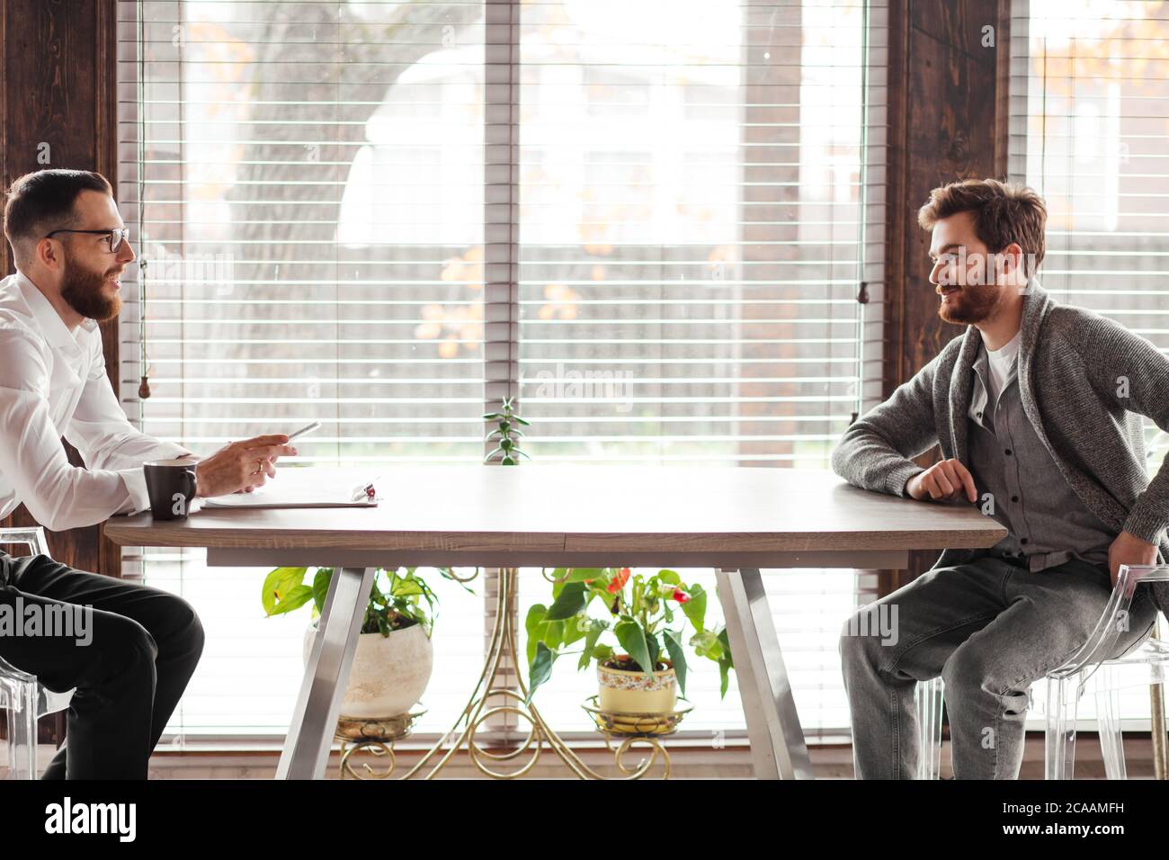 Business people sharing their ideas sitting in well lit airy stuff room ...