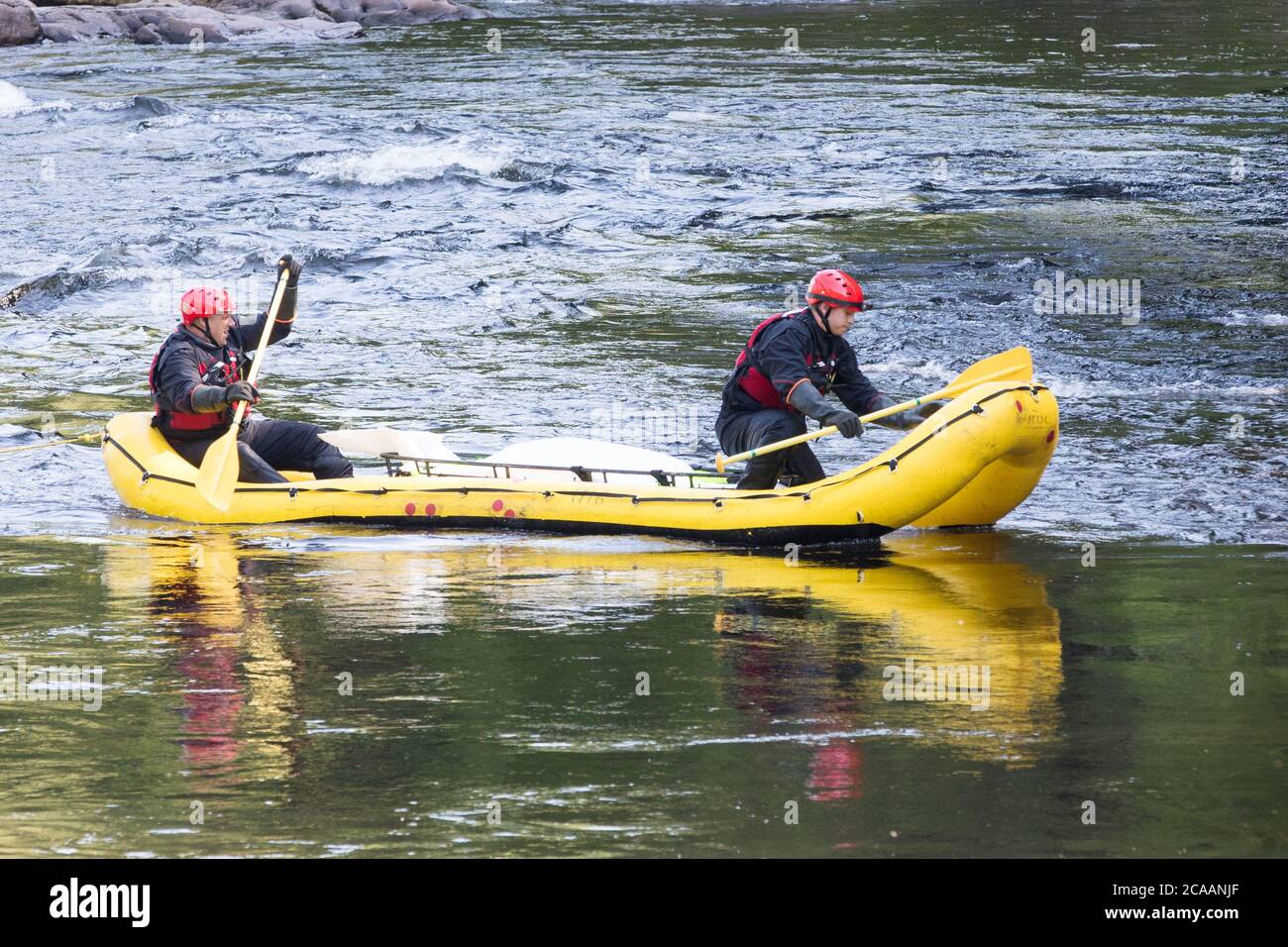 Firefighters try to reach drowning victim with inflatable boat Stock ...
