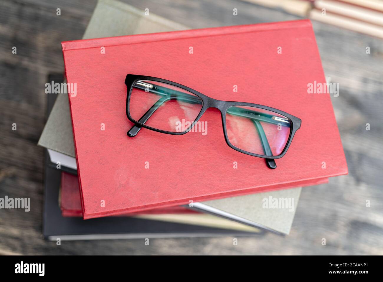 Top view of a stack of books with eyeglasses on top Stock Photo - Alamy