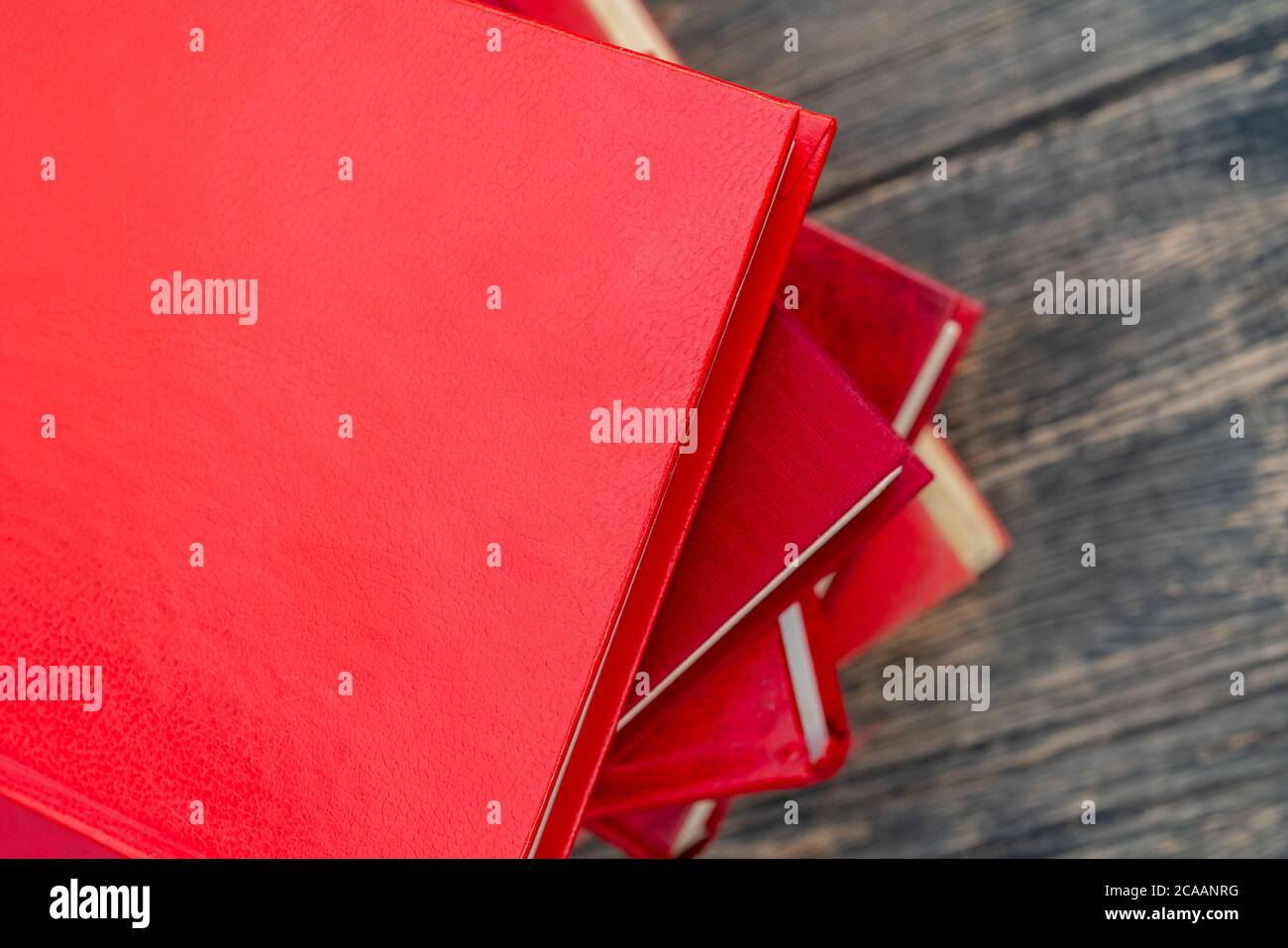 Top view of a stack of red books on wooden table Stock Photo - Alamy