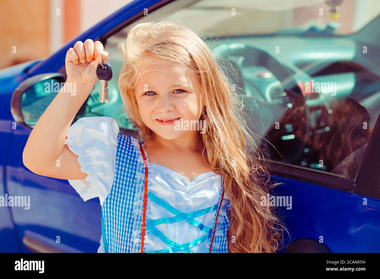 Pretty girl with long golden hair wearing princess dress and showing ...