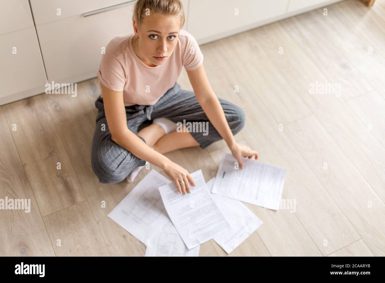 awesome girl sitting on the floor with documents and looking at the ...