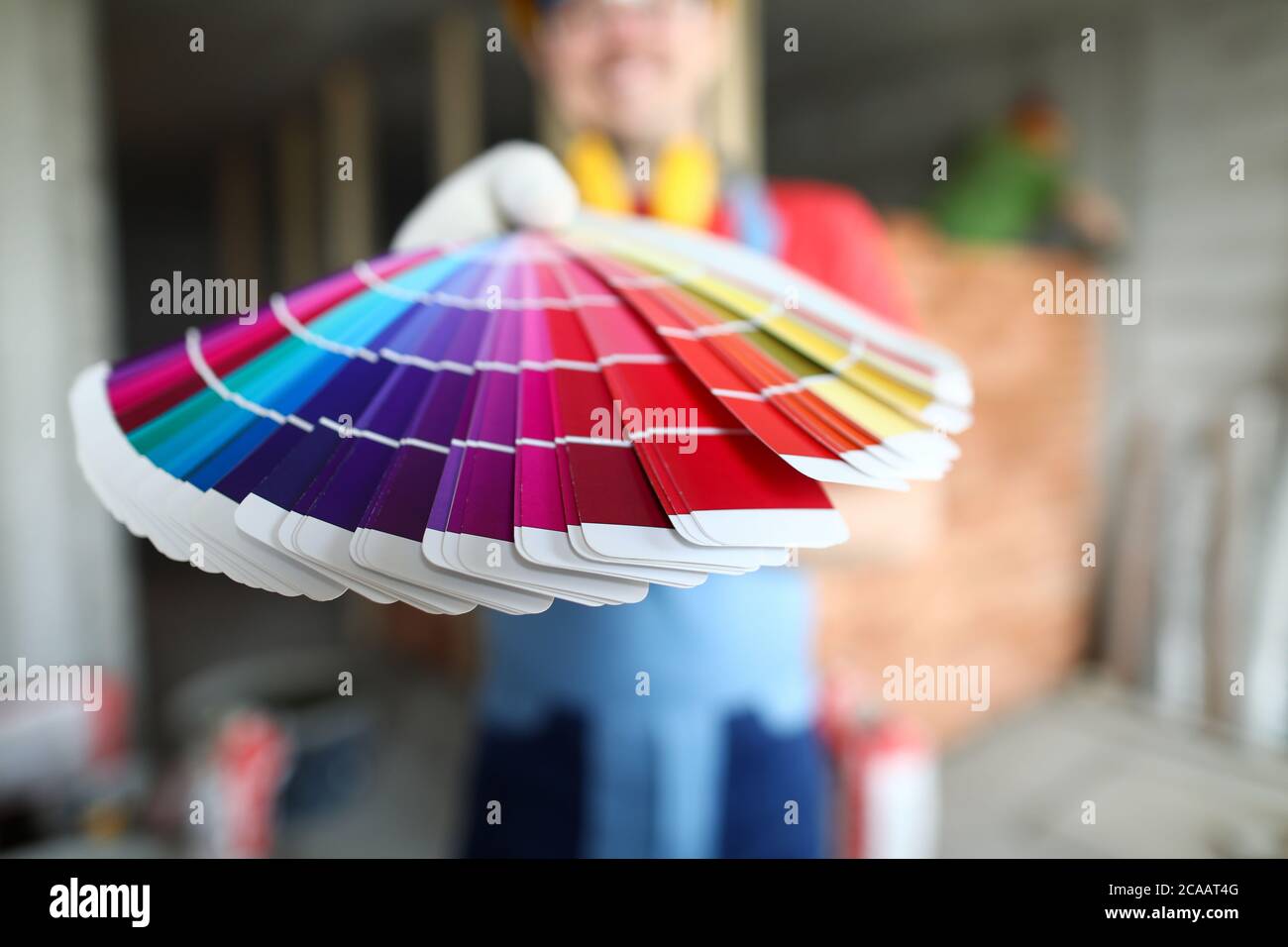 Builder holds out palette trendy colors for repair Stock Photo - Alamy
