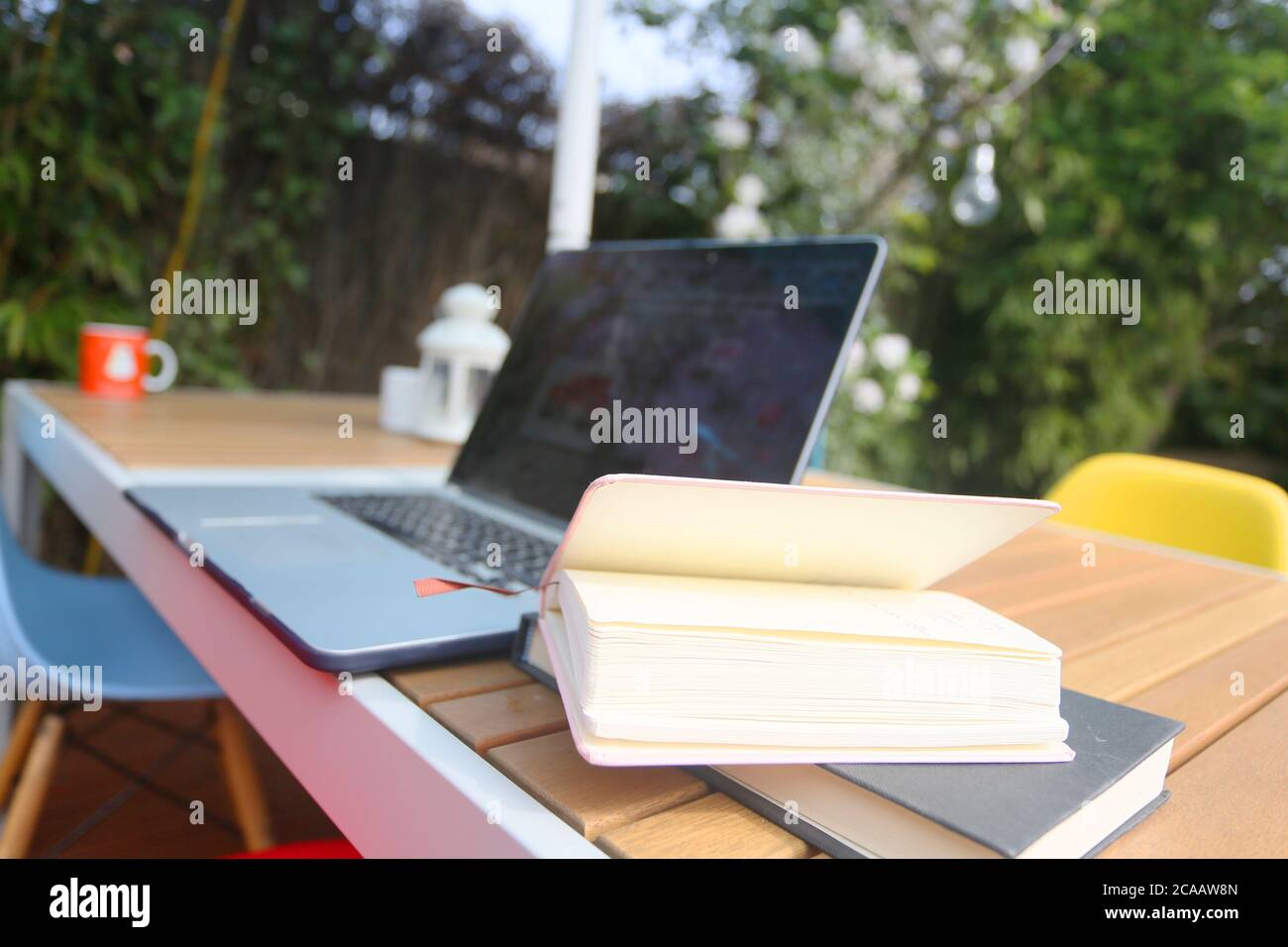 laptop and notepad in the garden as a home office outside working in ...