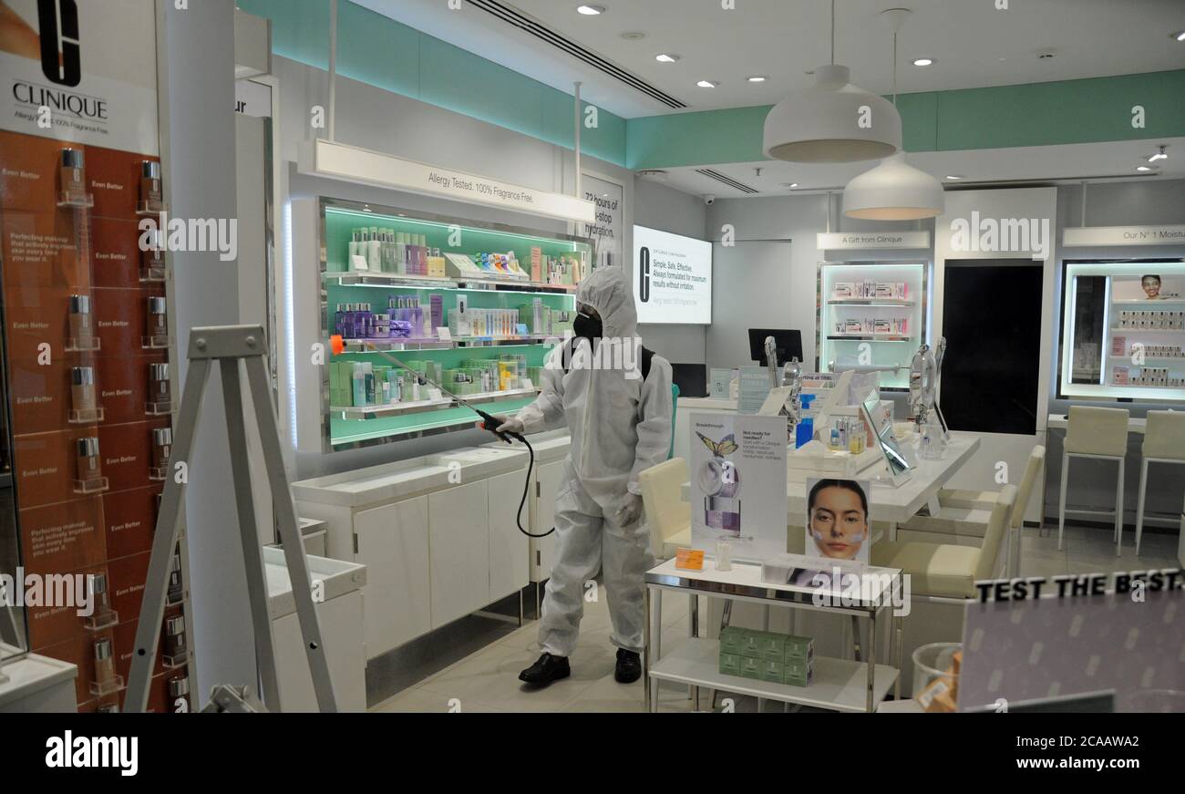 A man wearing a Personal Protective Equipment (PPE) sanitises a shop ...