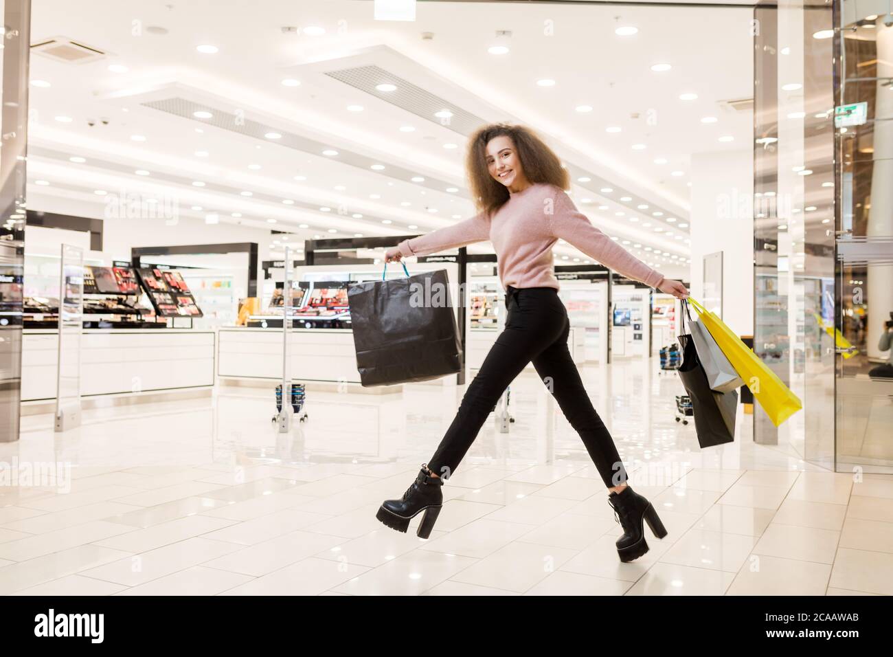 Happy girl with frizzy brown hair wearing skinny jeans and high heels ...