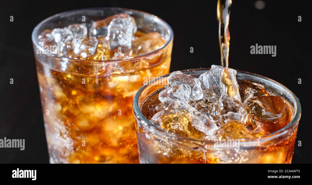 two cups of cola soft drink being poured into glass Stock Photo - Alamy
