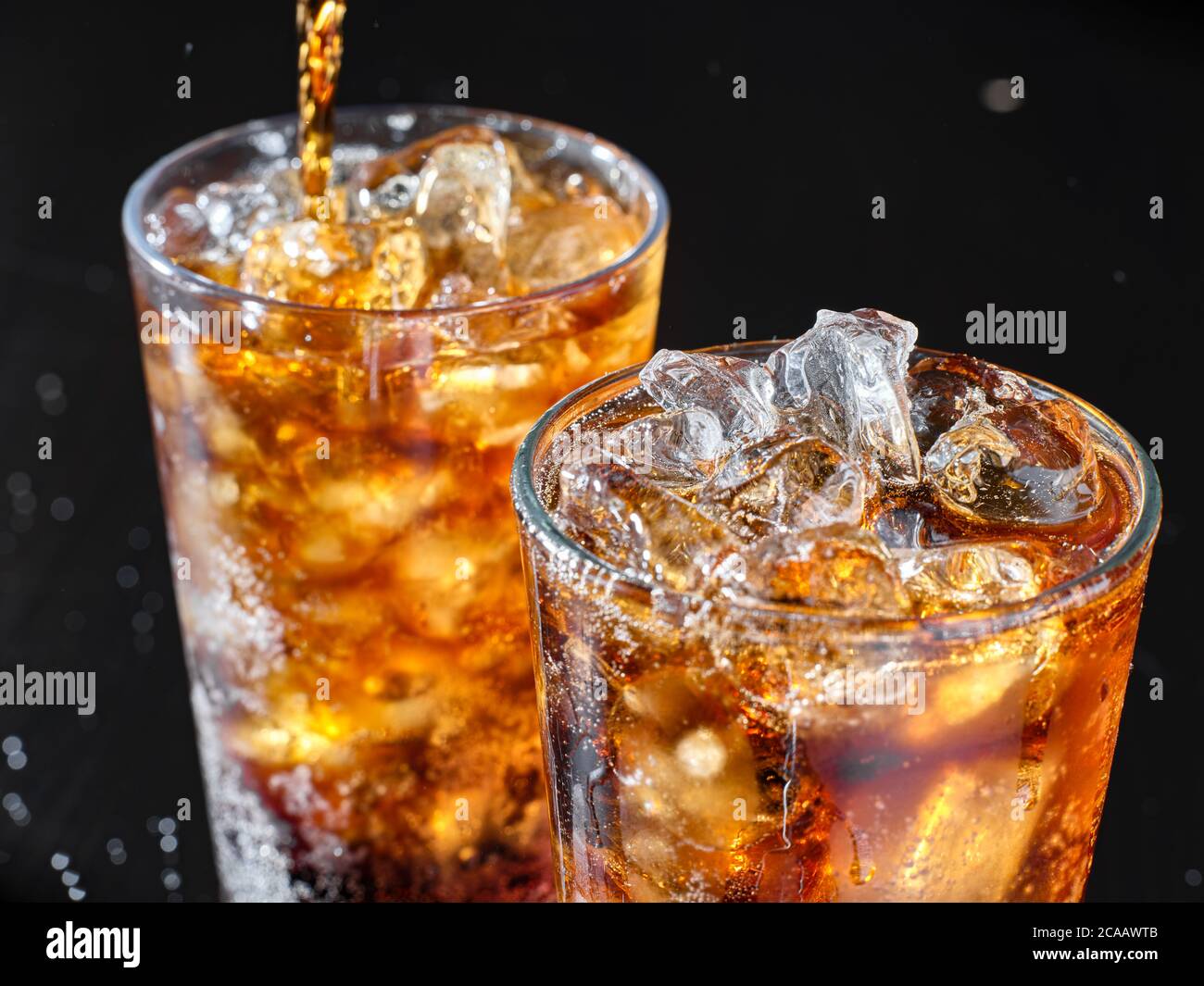 two cups of cola soft drink being poured into glass Stock Photo - Alamy