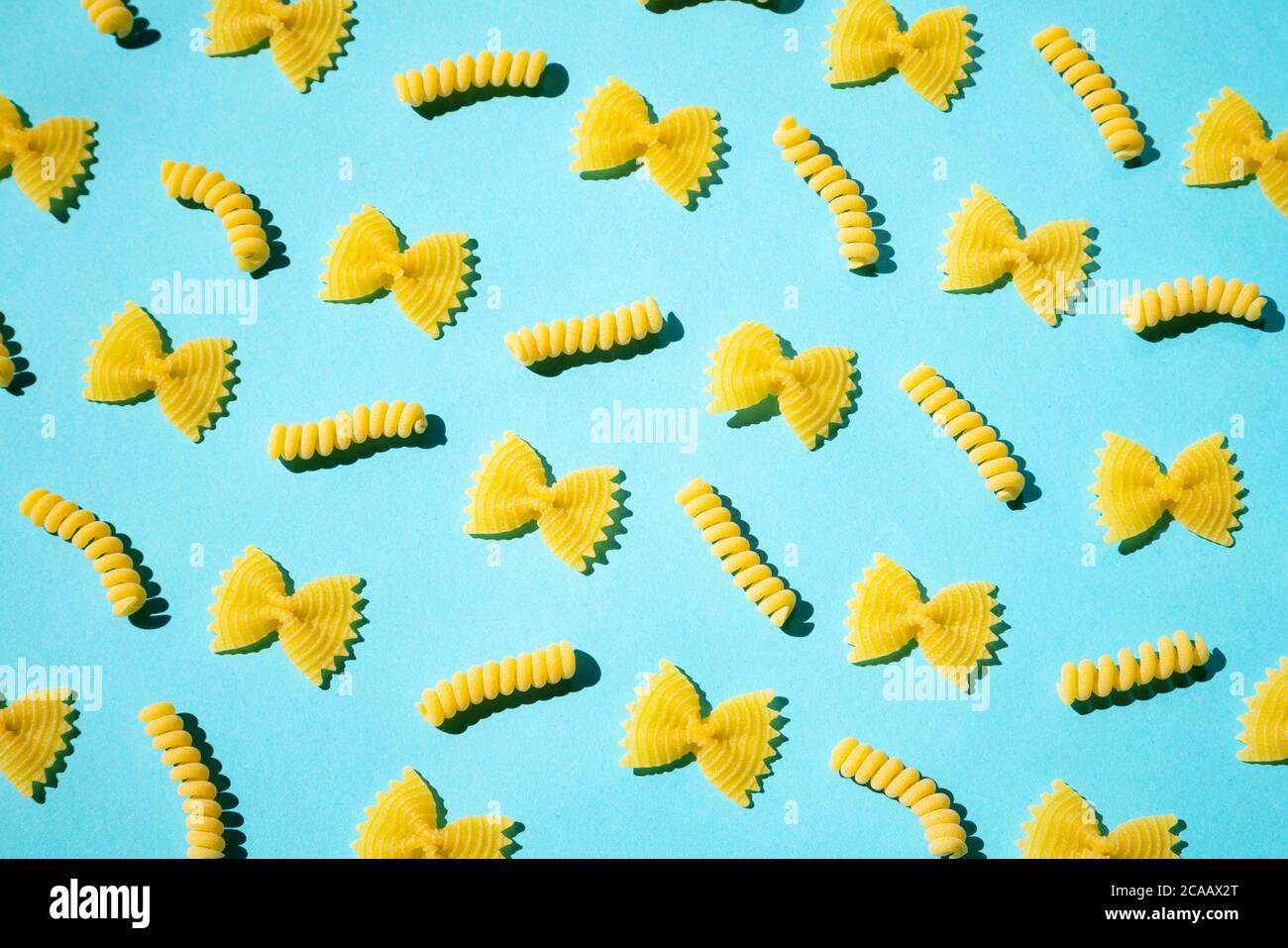 Uncooked curly pasta pattern on blue background. Traditional dry raw ...