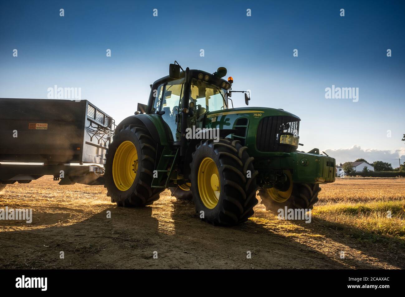 Tractor pulling a trailer Stock Photo - Alamy