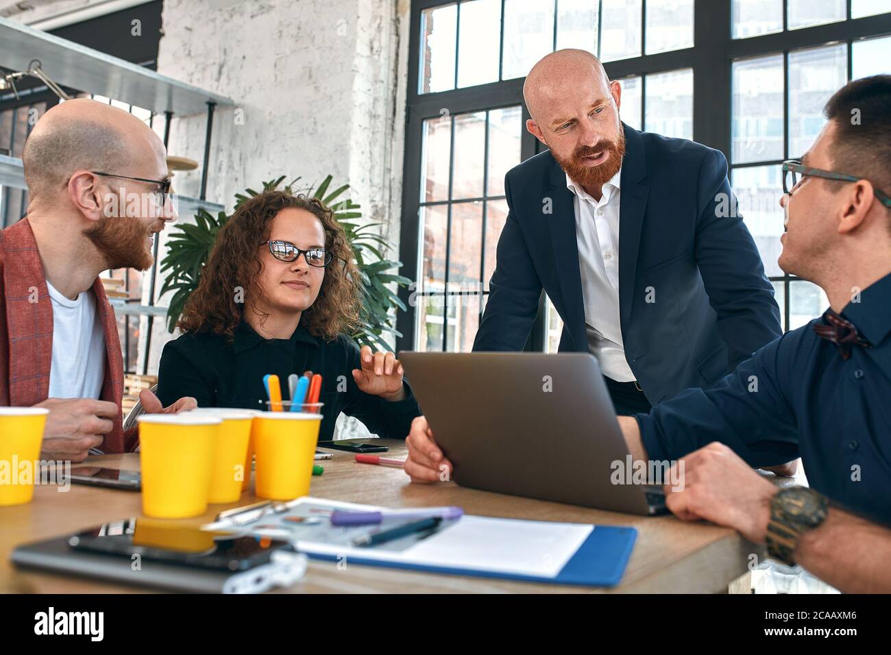 Beautiful business people are using gadgets, talking and smiling during ...