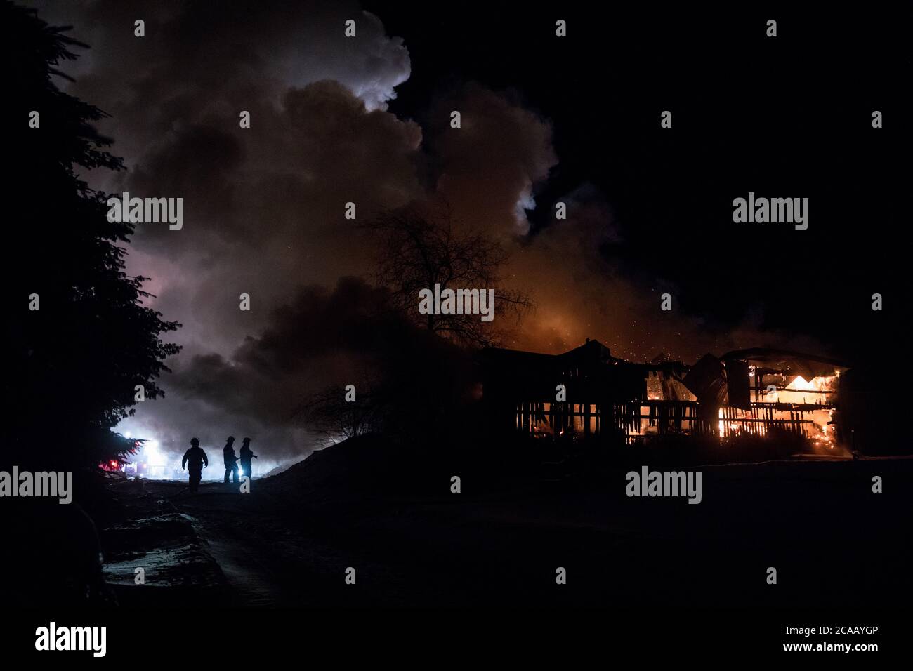 Blazing fire barn with firefighters in shadow Stock Photo - Alamy
