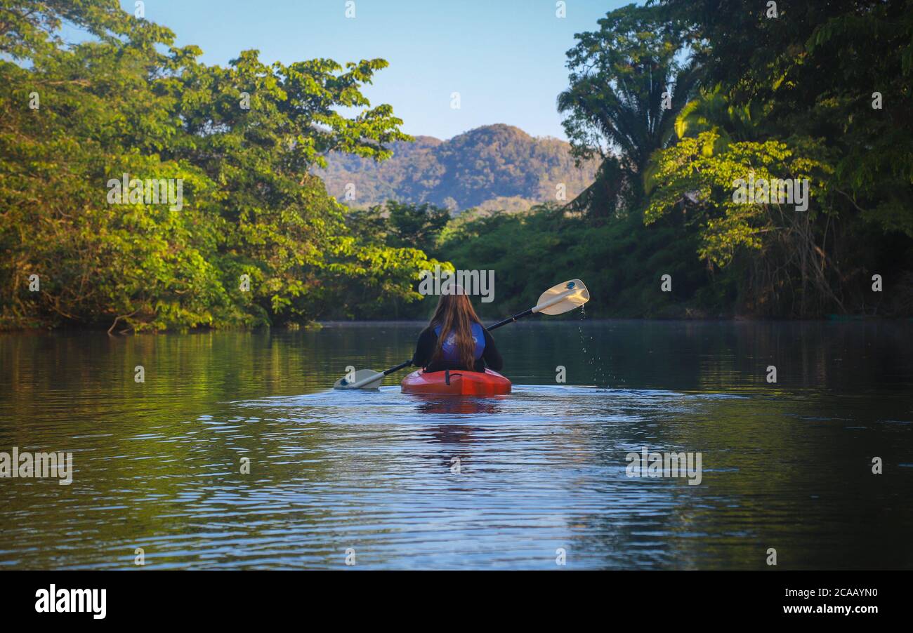 PUNTA GORDA, BELIZE - Feb 16, 2019: A young woman paddles along the ...