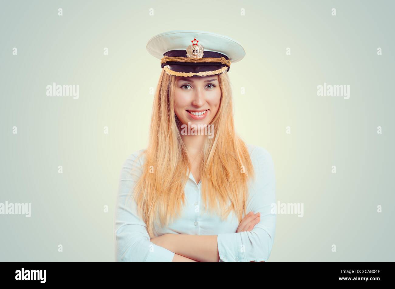 Pretty blond woman in white shirt and white navy service cap smiling at ...