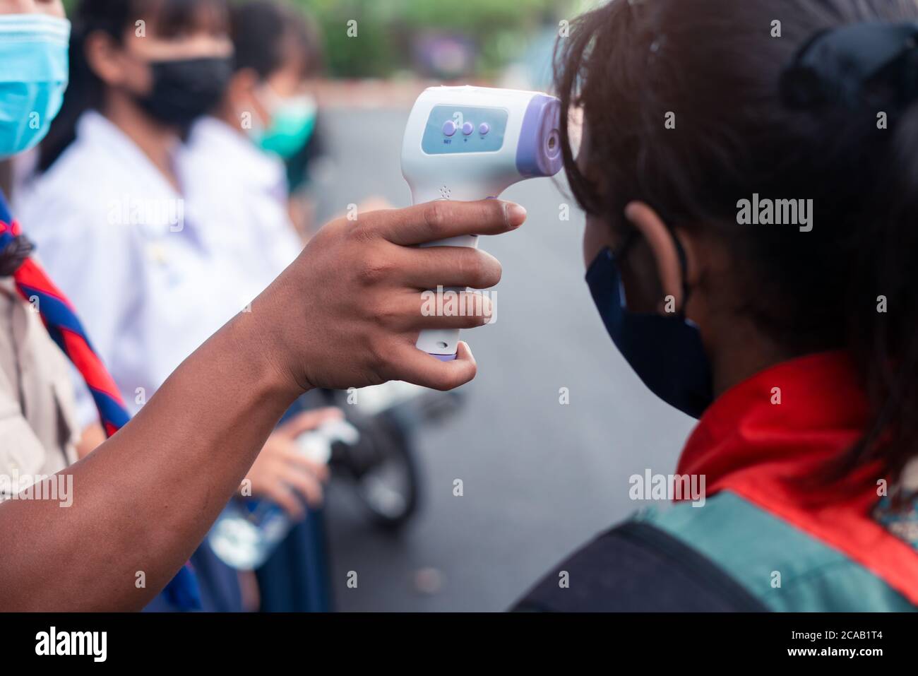 Hand holding Infrared thermometer gun forehead temperature test to ...