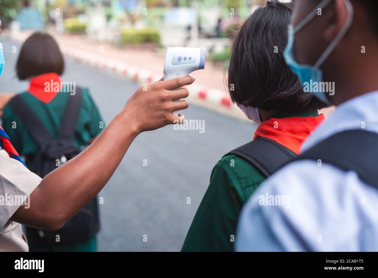 Hand holding Infrared thermometer gun forehead temperature test to ...