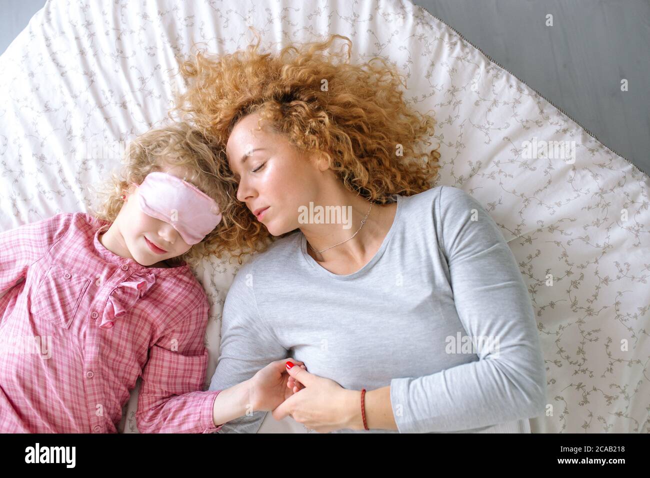 resting mommy and her lovely child. sleeping double. family having a ...