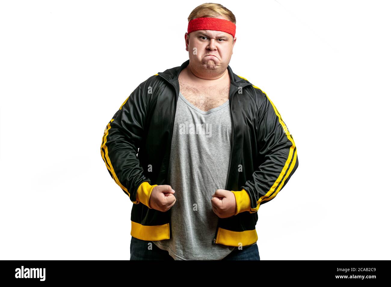 Big overweighted grumpy man in sportive jacket and red headband makes ...