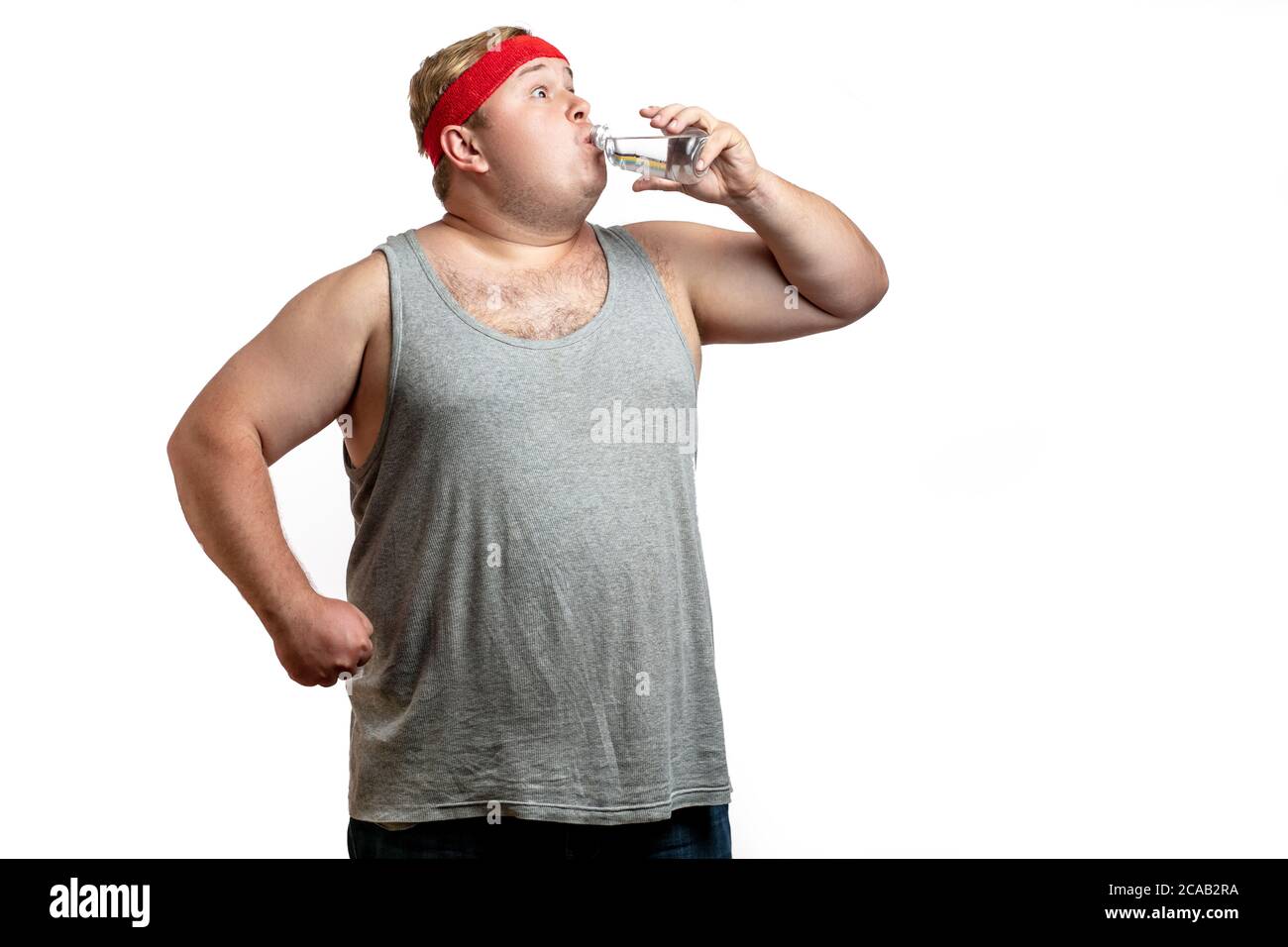 Tired overweight caucasian man in sportive oversize singlet drinking ...