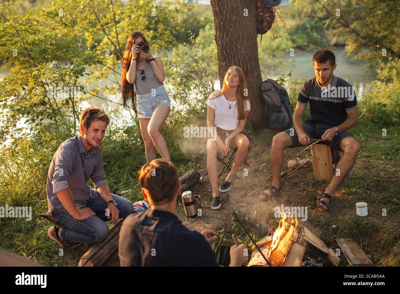 pretty girl is using camera to shoot beautiful bonfire at camp Stock ...