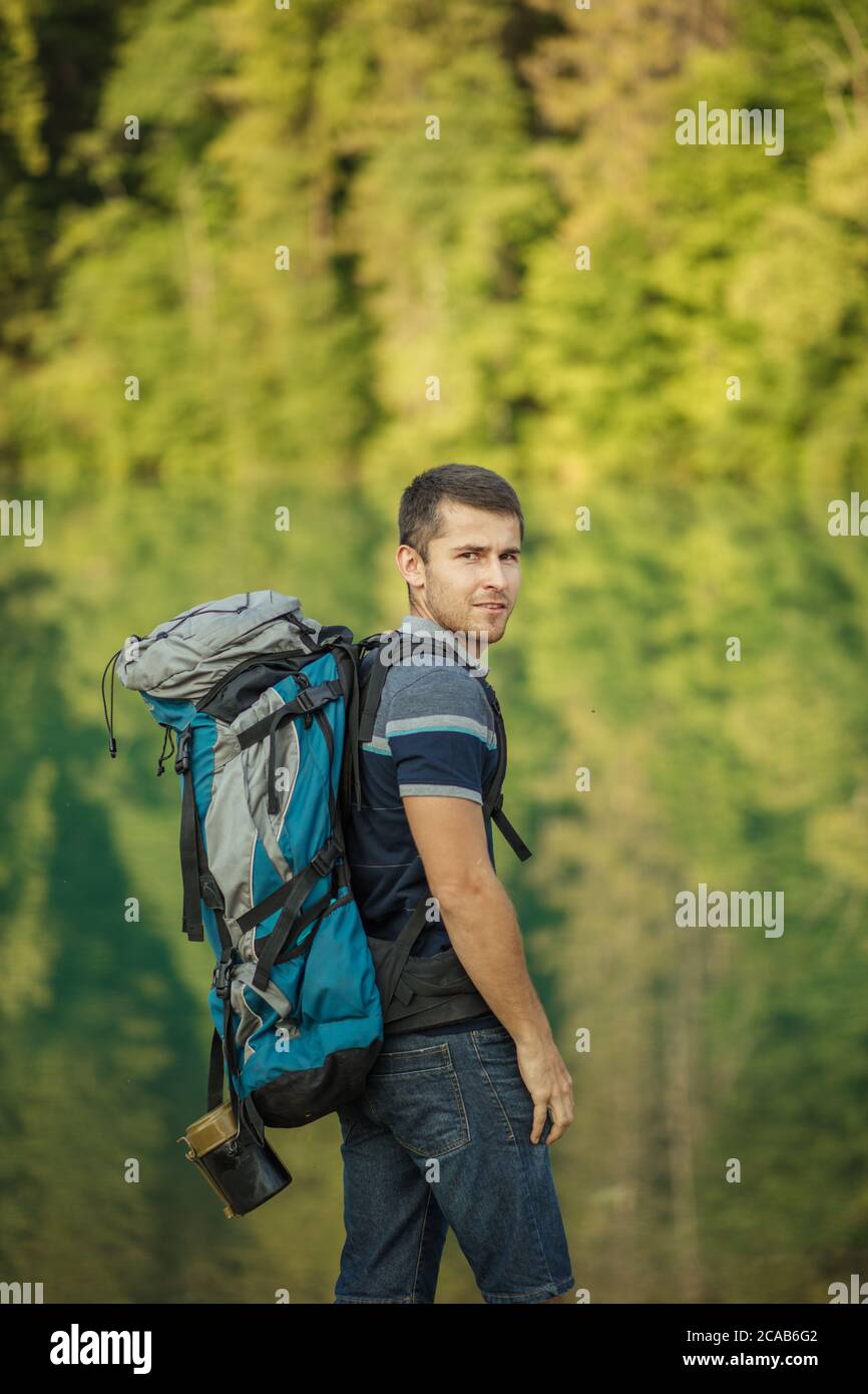 close up portrait of an adventurous guy with rucksack going hiking with ...