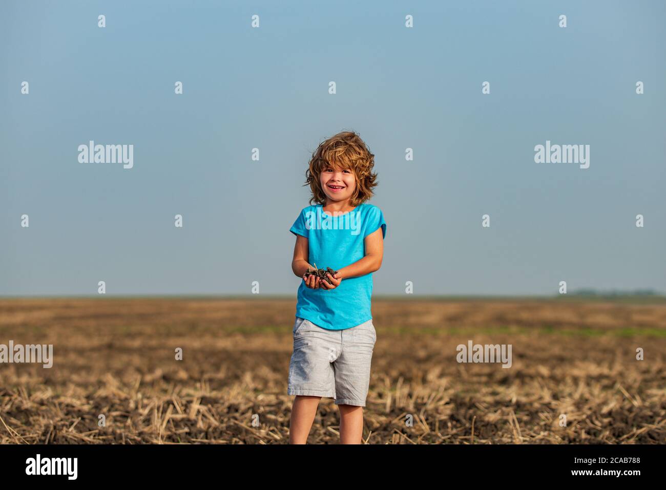 Cute child on the black soil background. Soils and fertilizers Stock ...