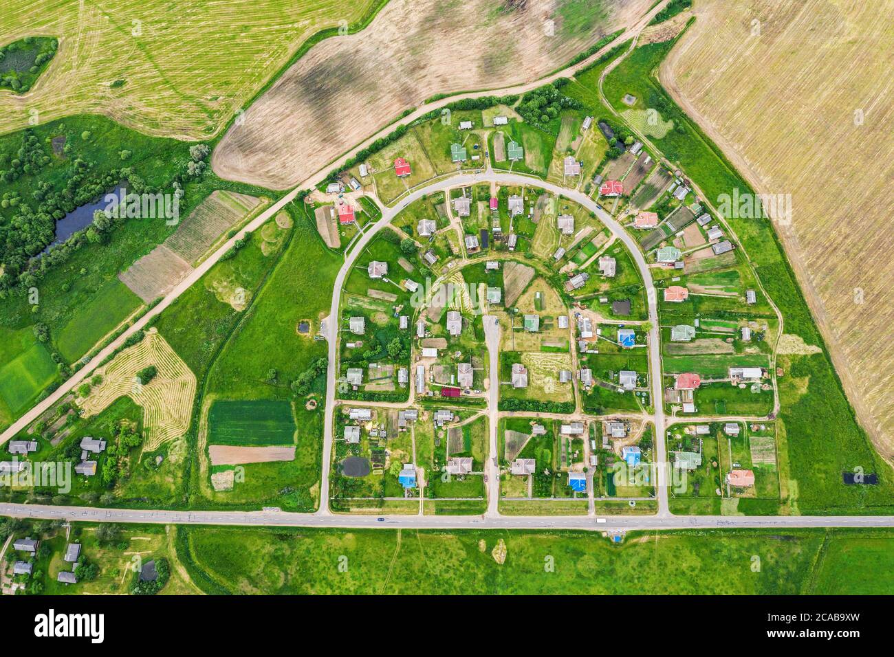 top down aerial drone image of village in countryside between green ...