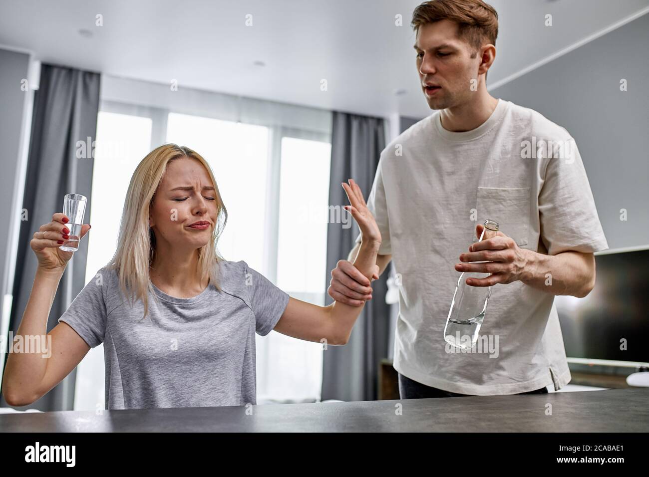 stop drinking alcohol man try to stop his woman from drinking, hold her ...