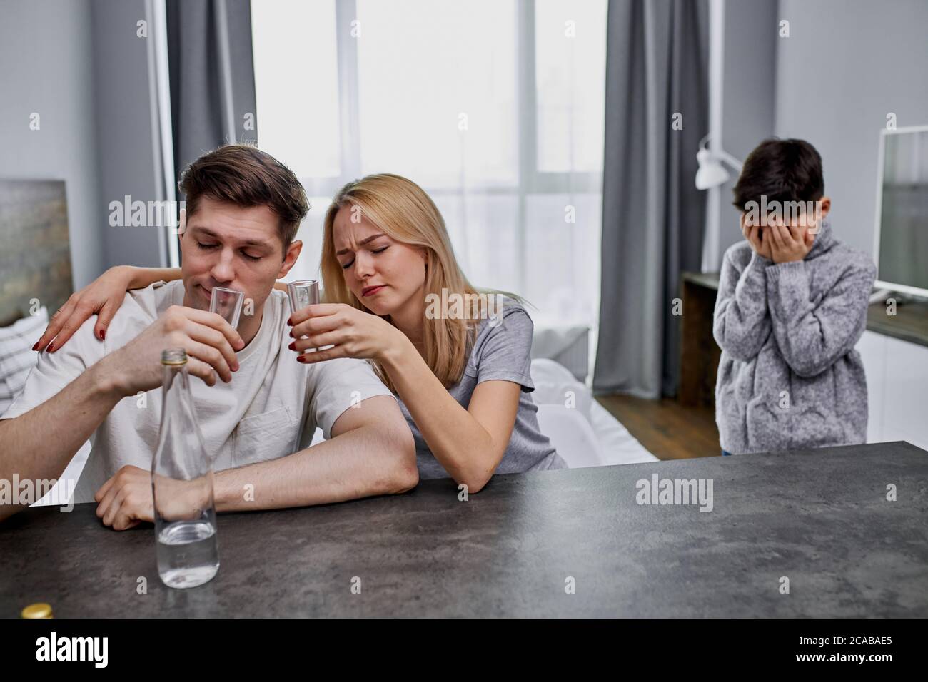 desperate child tired of parents alcoholics, man and woman drink ...