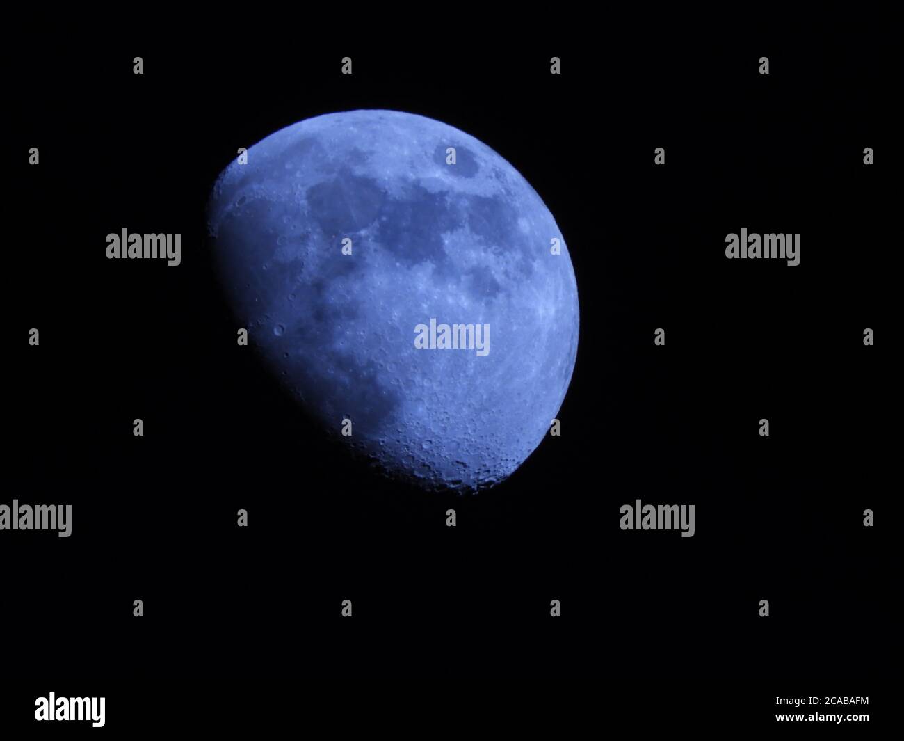 Blue half-moon in the black sky at night Stock Photo - Alamy