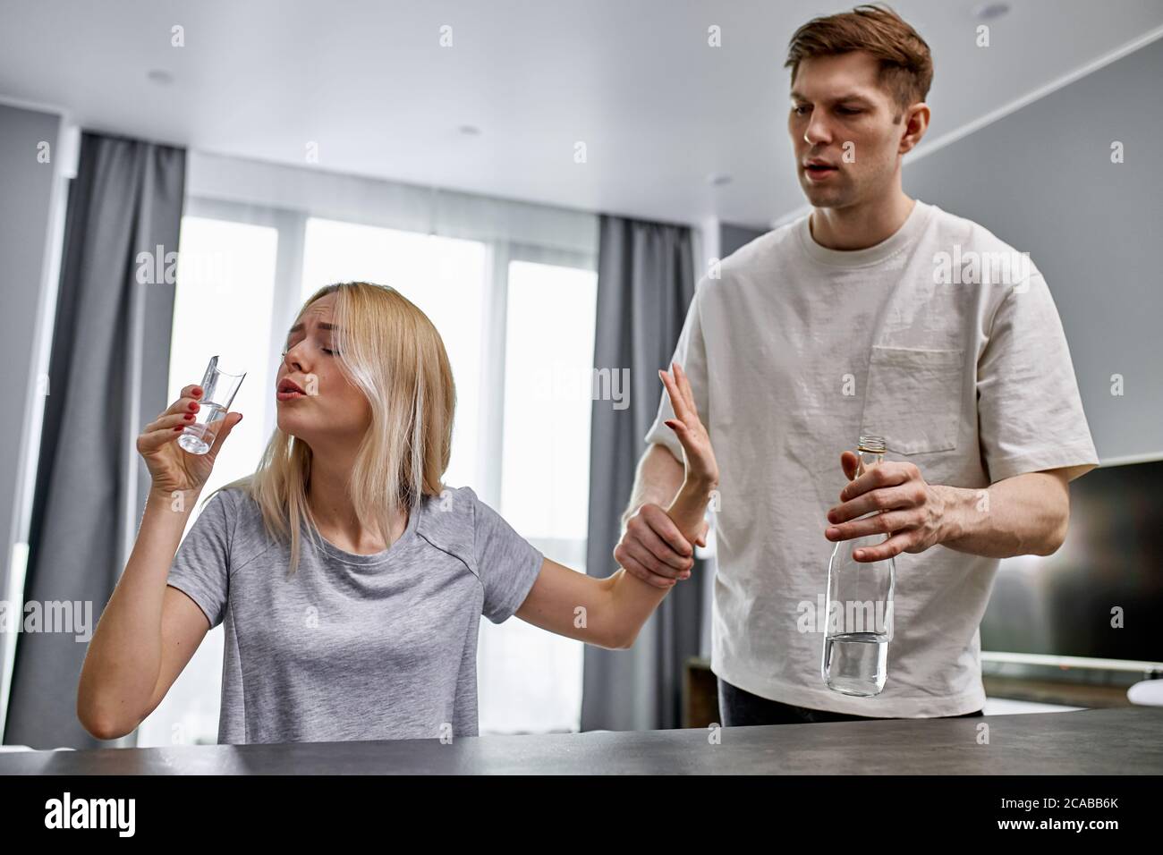 stop drinking alcohol man try to stop his woman from drinking, hold her ...