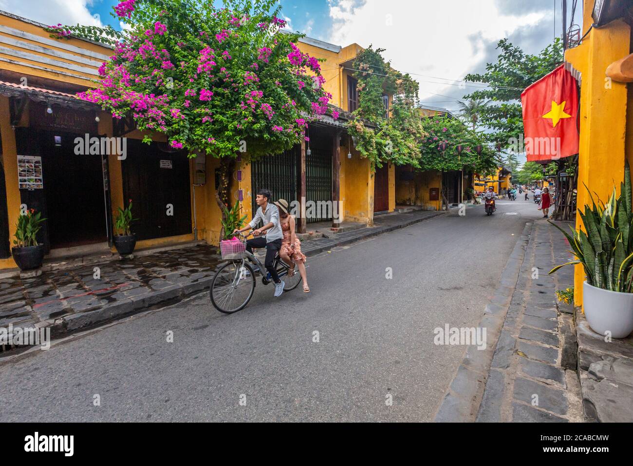 Locals ride bicycle in the historical town of Hoi An, Quang Nam ...