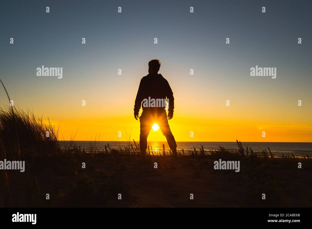 Silhouette of a man jumping and enjoying a sunset on the beach Stock Photo - Alamy