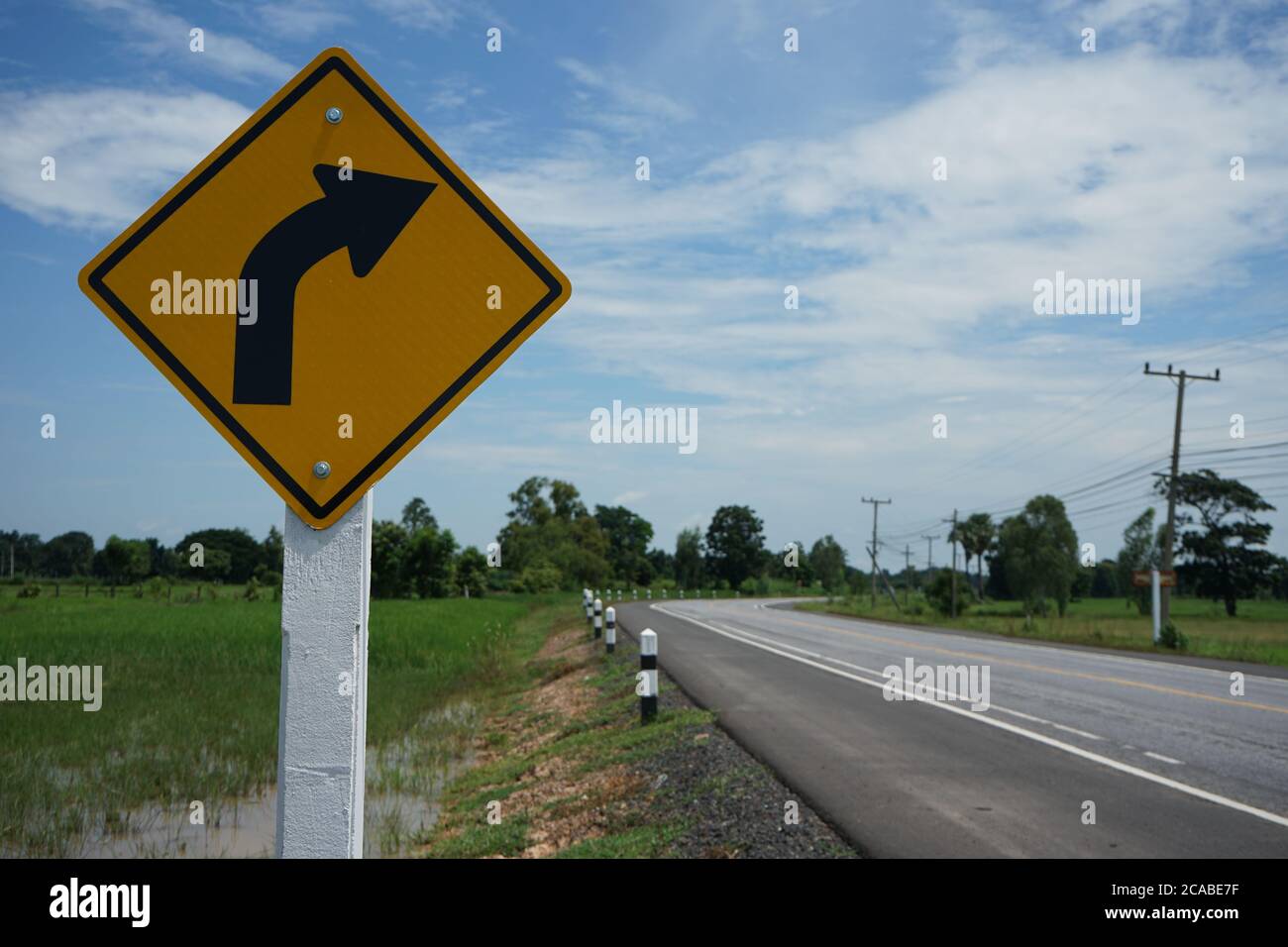 Warning sign for curving road guide Stock Photo - Alamy
