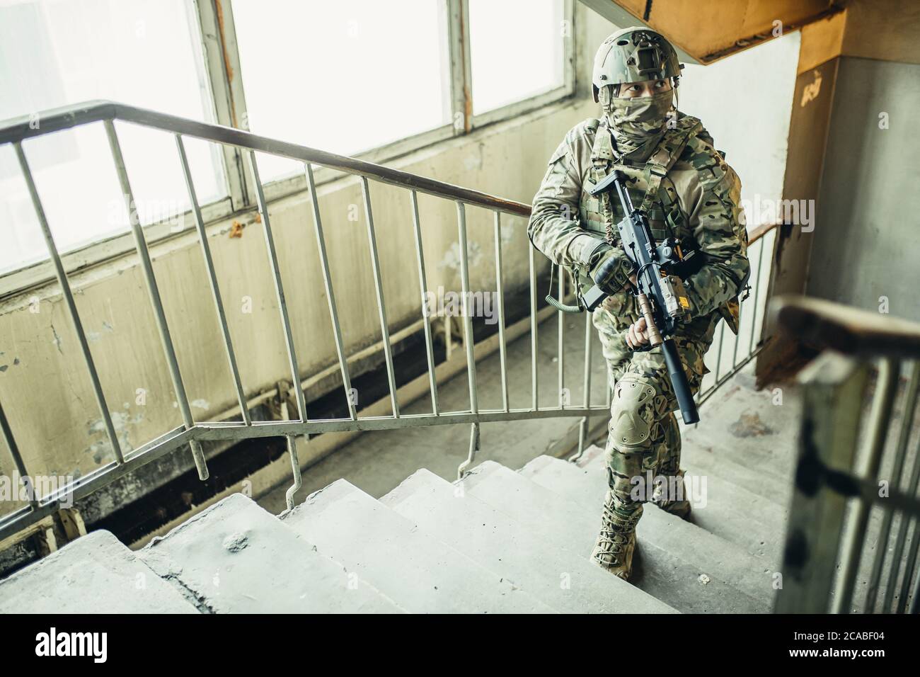 young fearless soldier with weapon in danger, wearing green wear for ...