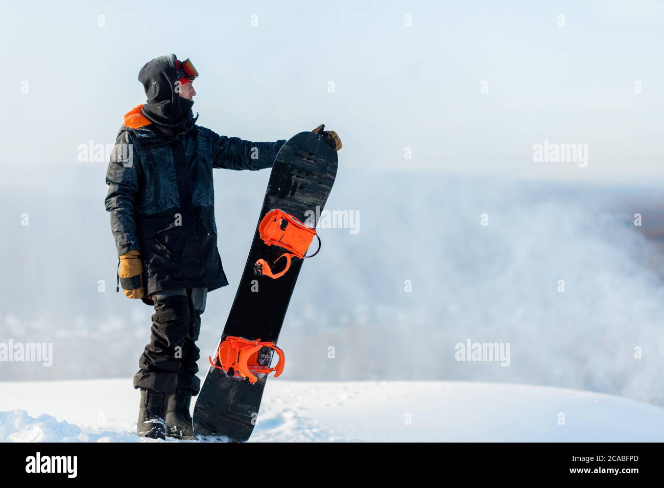 awesome athlete standing on the peak of the mountains and looking into ...