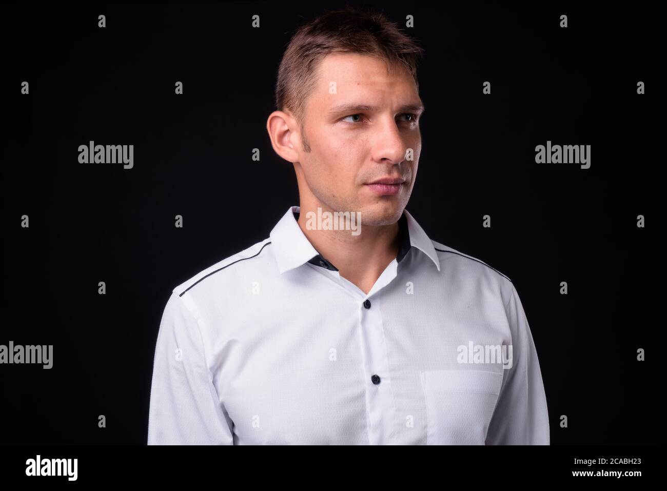 Portrait of businessman thinking against black background Stock Photo ...