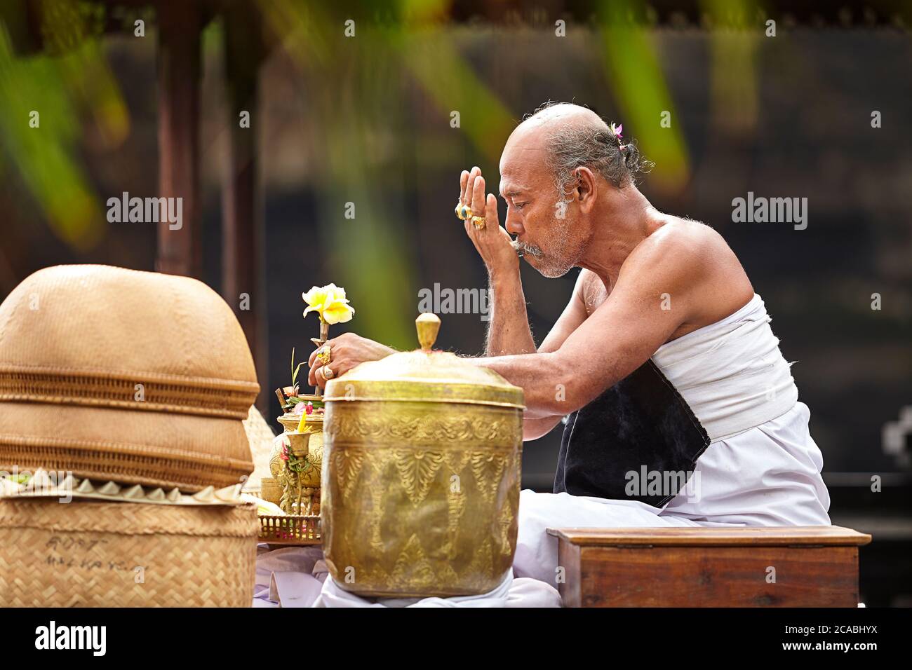 A Balinese Hindu religious ceremony leader prays for water to be used ...