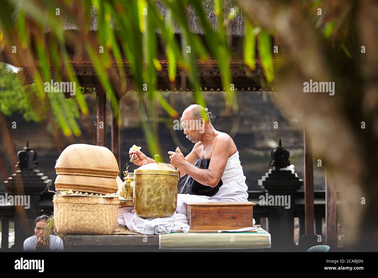 A leader of Balinese Hindu religious ceremonies praying in a ritual ...