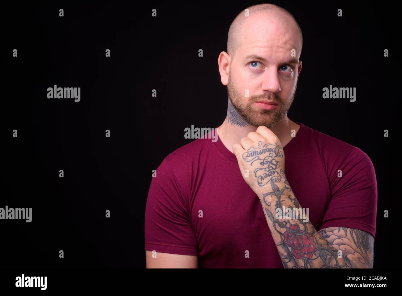 Handsome bald bearded man against black background Stock Photo - Alamy