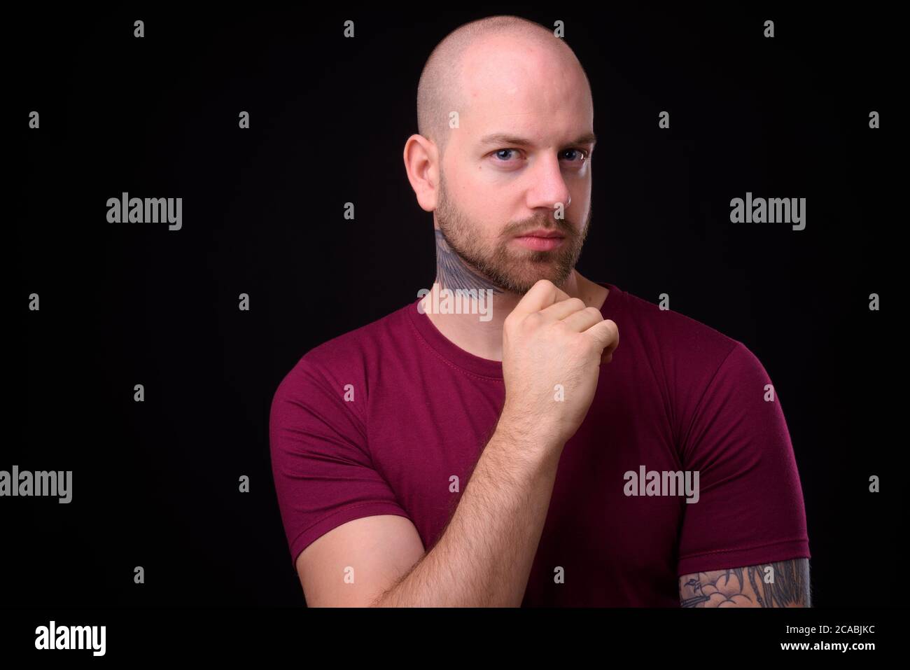 Handsome bald bearded man against black background Stock Photo - Alamy