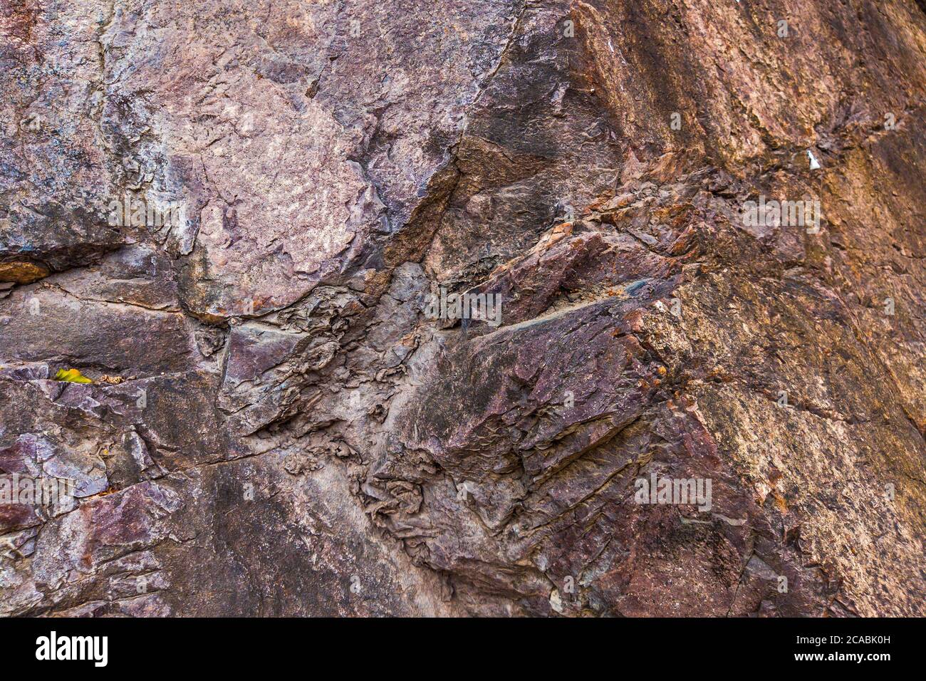 Closeup of dark dged shabby cliff cracks. Gray stone rock texture of ...